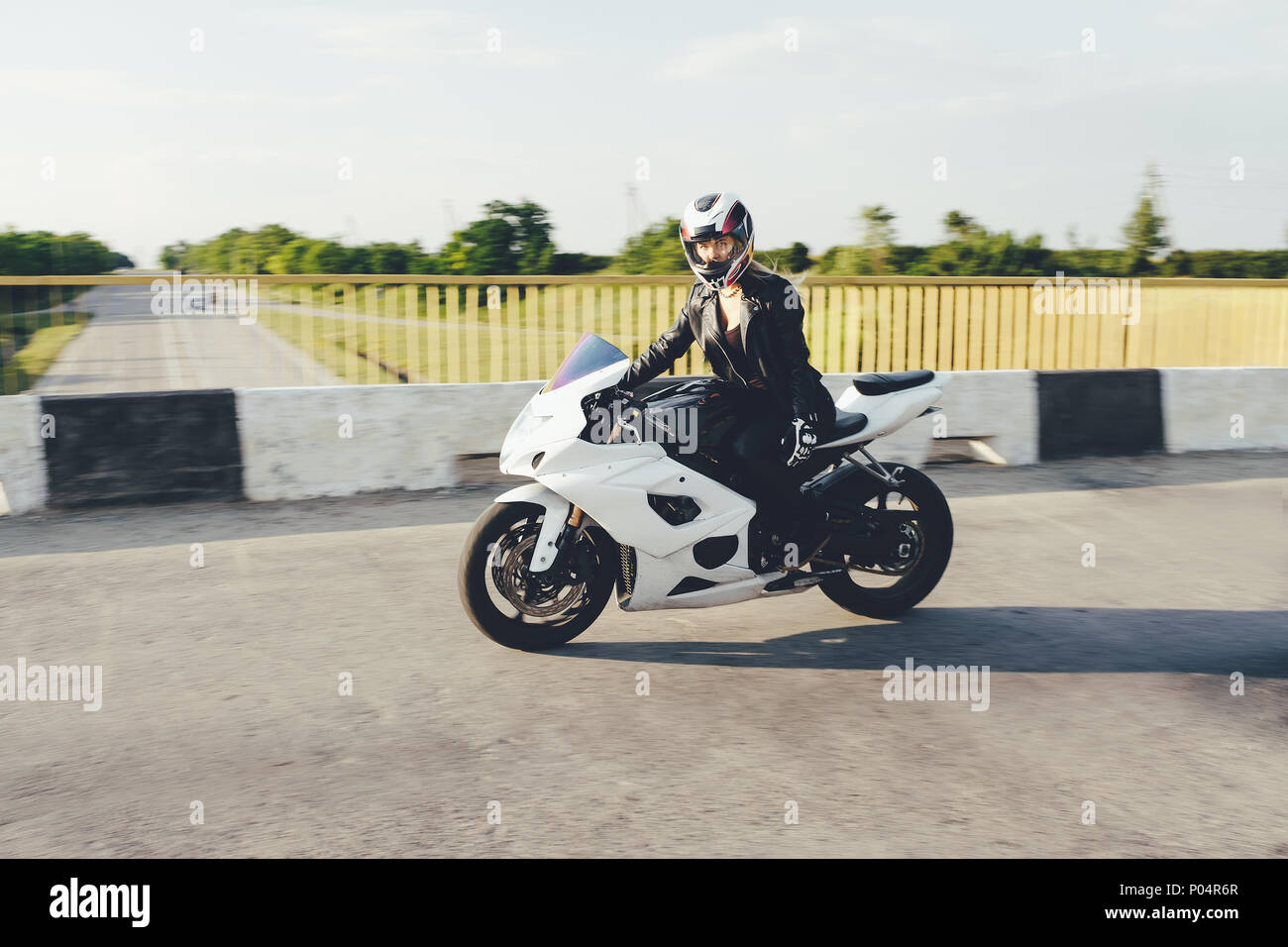 Woman biker driving a motorbike on a road Stock Photo - Alamy