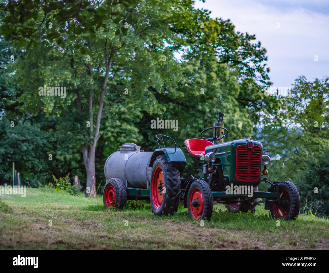 Old fashioned tractor sitting outside on grass Stock Photo - Alamy
