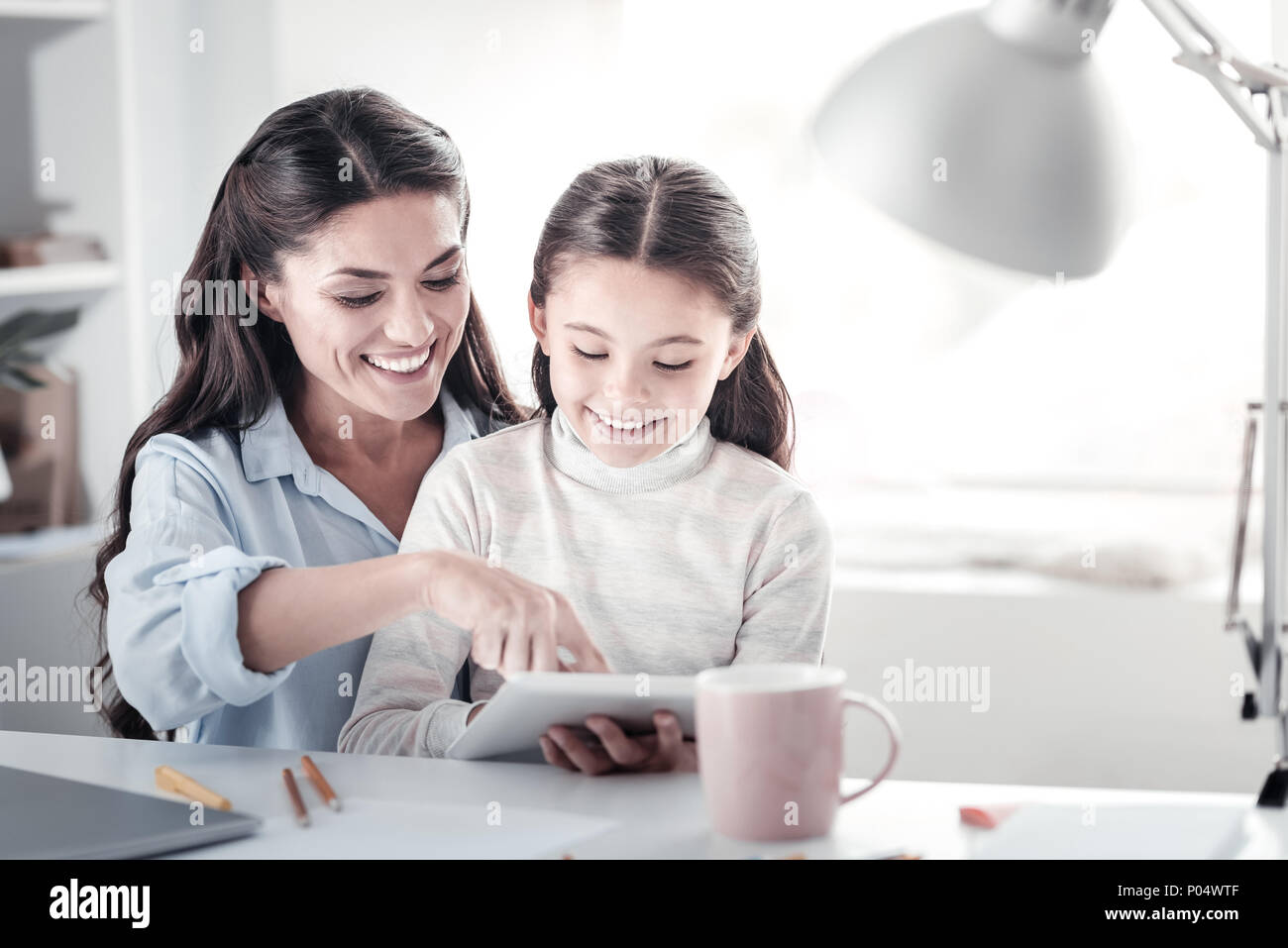 Happy brunette woman spending time with daughter Stock Photo - Alamy
