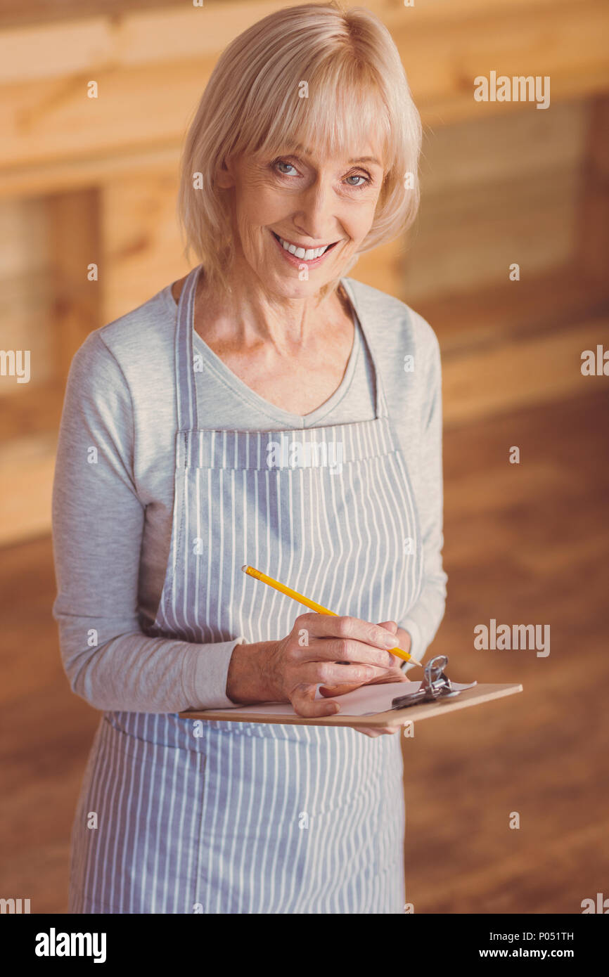 Top view of pleasant senior waitress making notes Stock Photo - Alamy