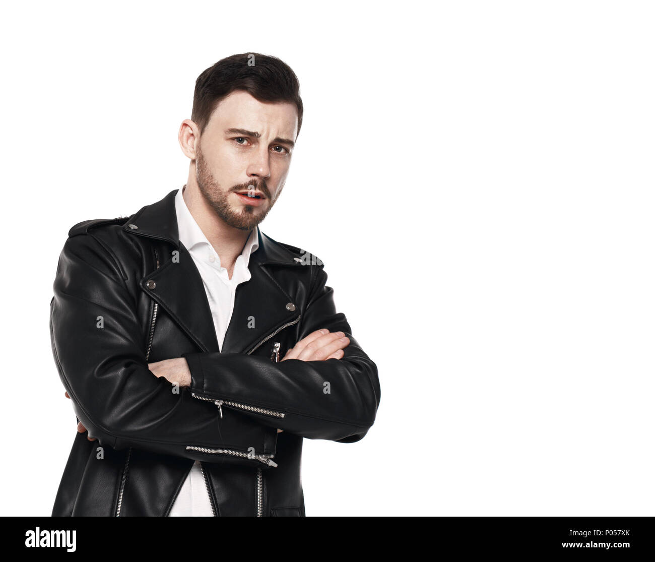 A stylish successful man stands with his arms crossed over his chest ...