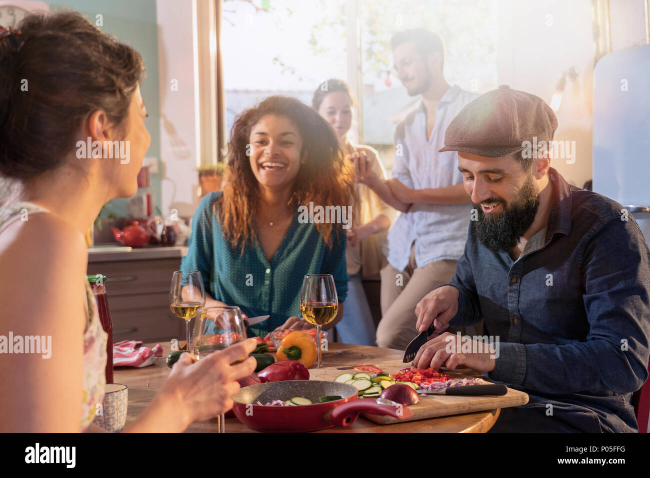 Mixed group of friends having fun while cooking lunch in kitchen Stock ...