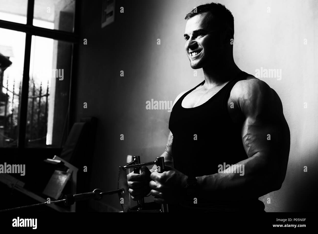 Handsome Bodybuilder Doing Heavy Weight Exercise For Back On Machine ...