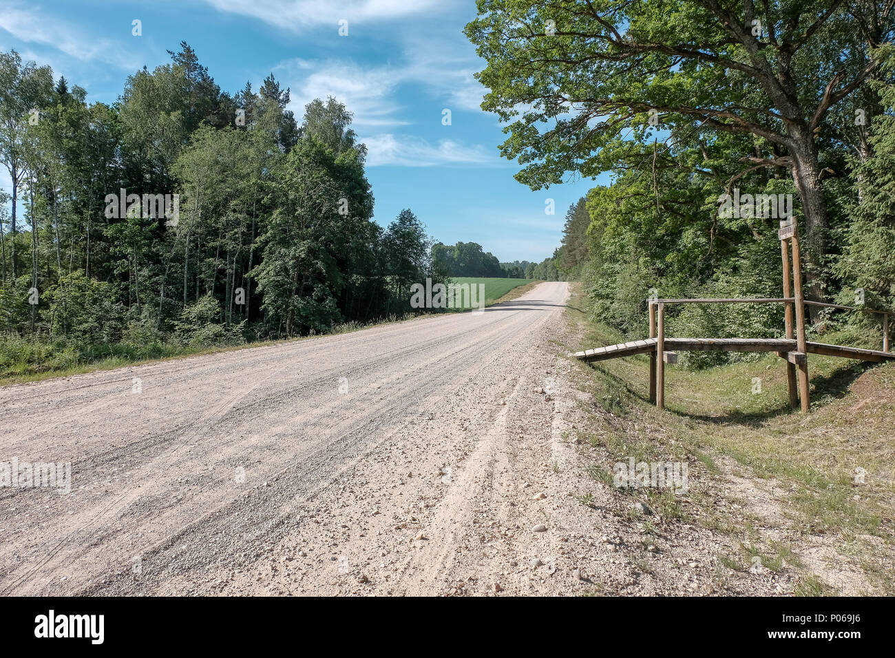 empty gravel road with tracks of mud in the countryside in summer heat ...