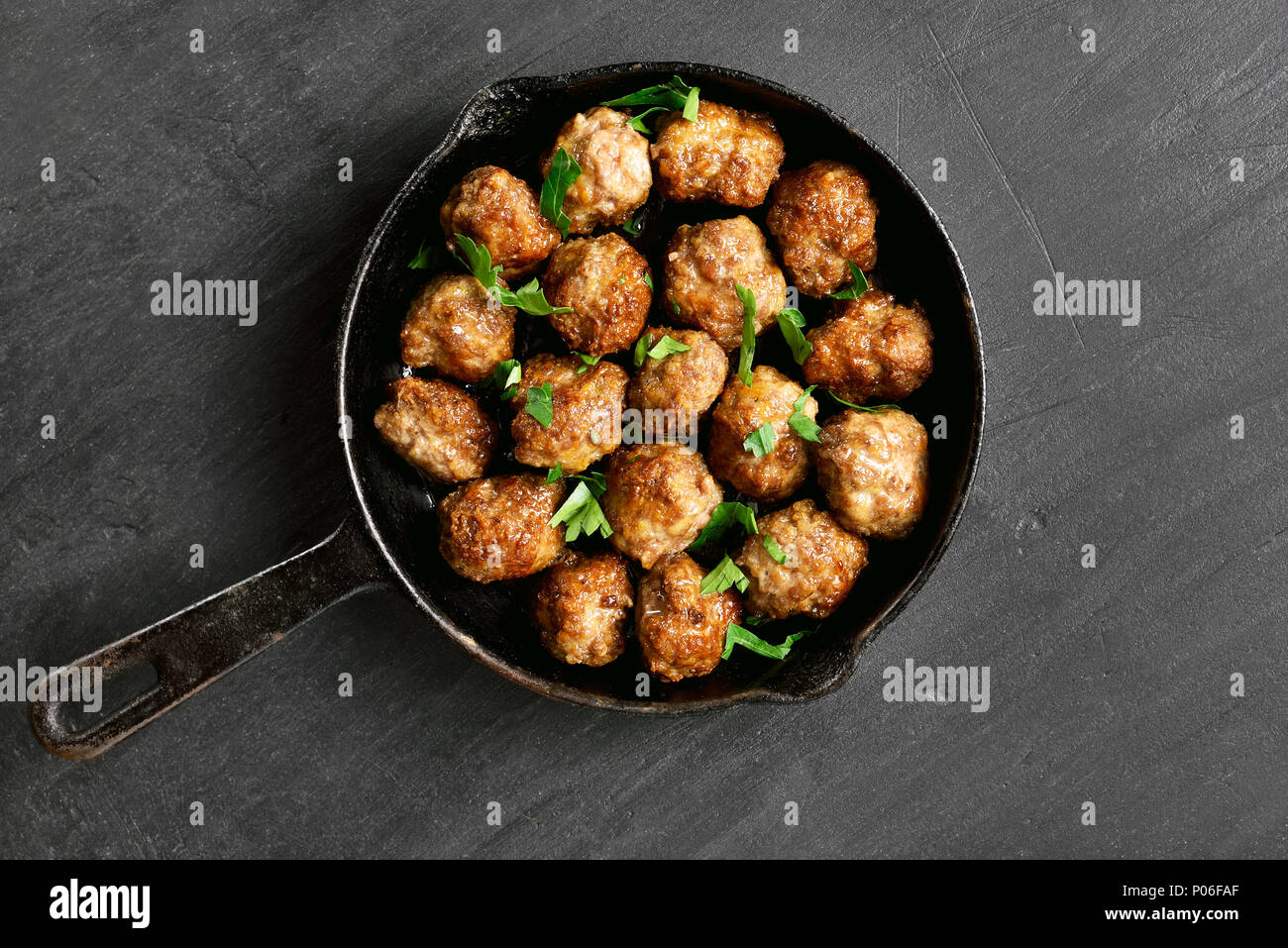 Meatballs in frying pan on black stone background. Top view, flat lay ...
