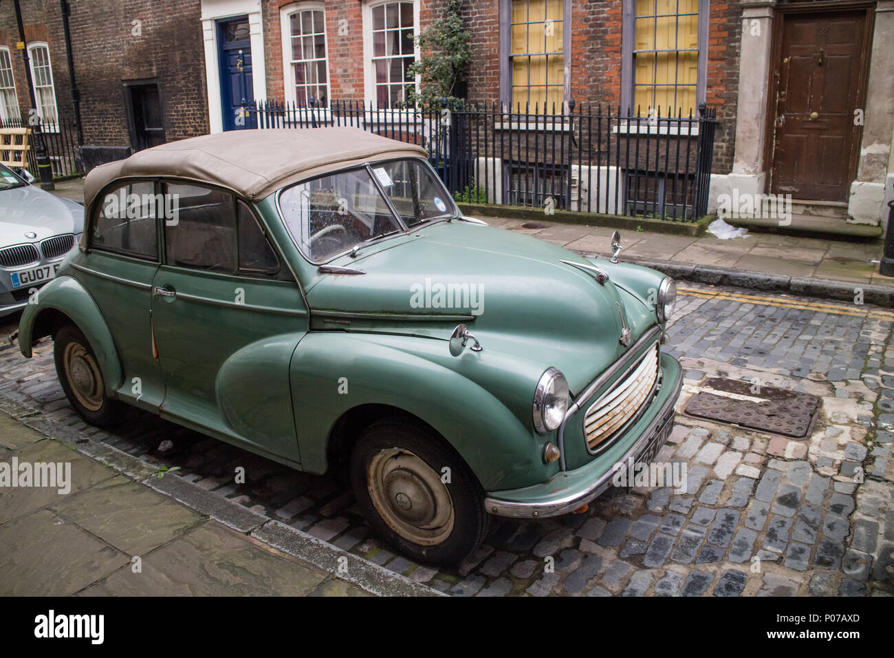 A lovely old pale green morris minor classic car is parked in a old ...