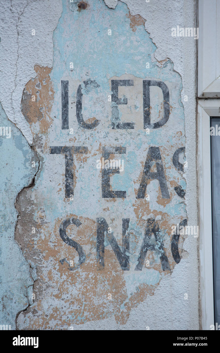 Very old seaside cafe wall painted sign reading "iced teas, snacks ...