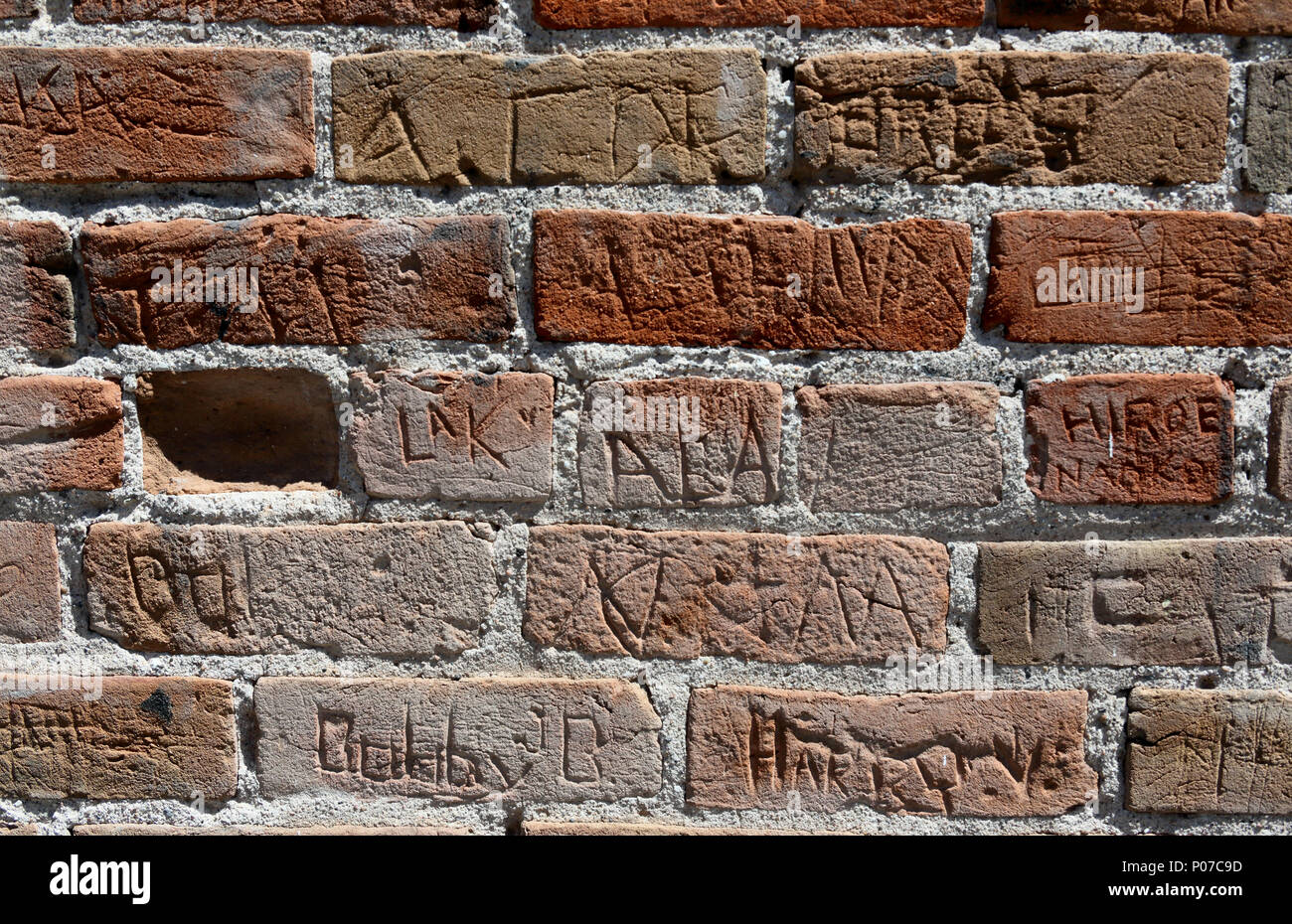 Red brick wall with multiple names embedded in the brick Stock Photo ...