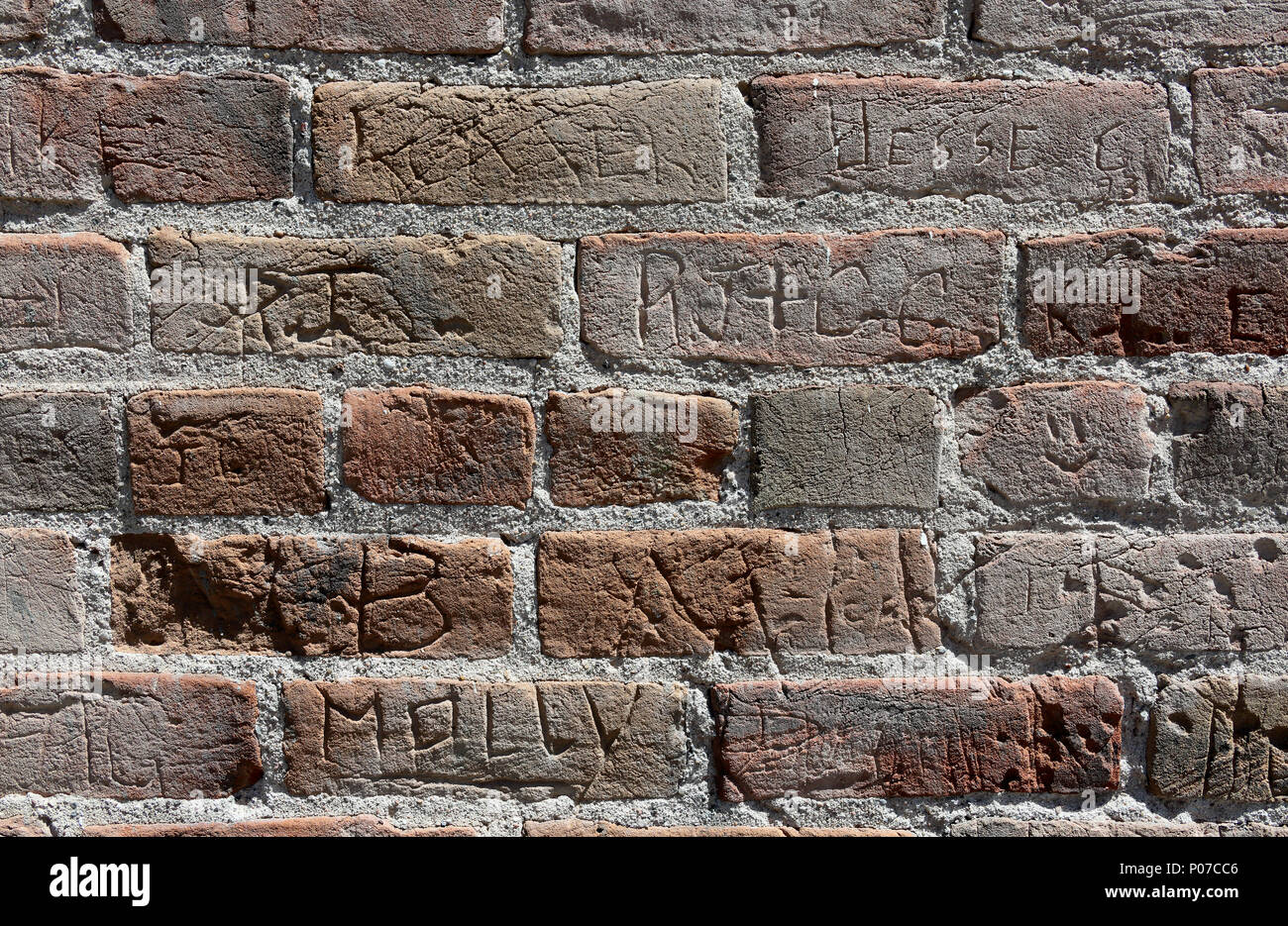Red brick wall with multiple names embedded in the brick Stock Photo ...