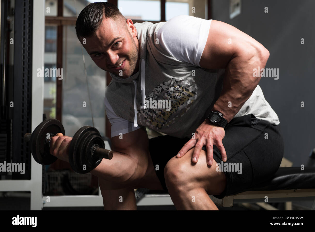 Man Working Out Biceps In A Gym - Dumbbell Concentration Curls Stock ...