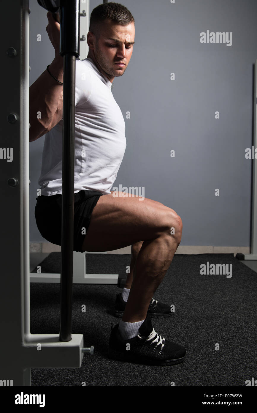 Man Working Out Legs With Barbell In A Gym - Squat Exercise Stock Photo ...