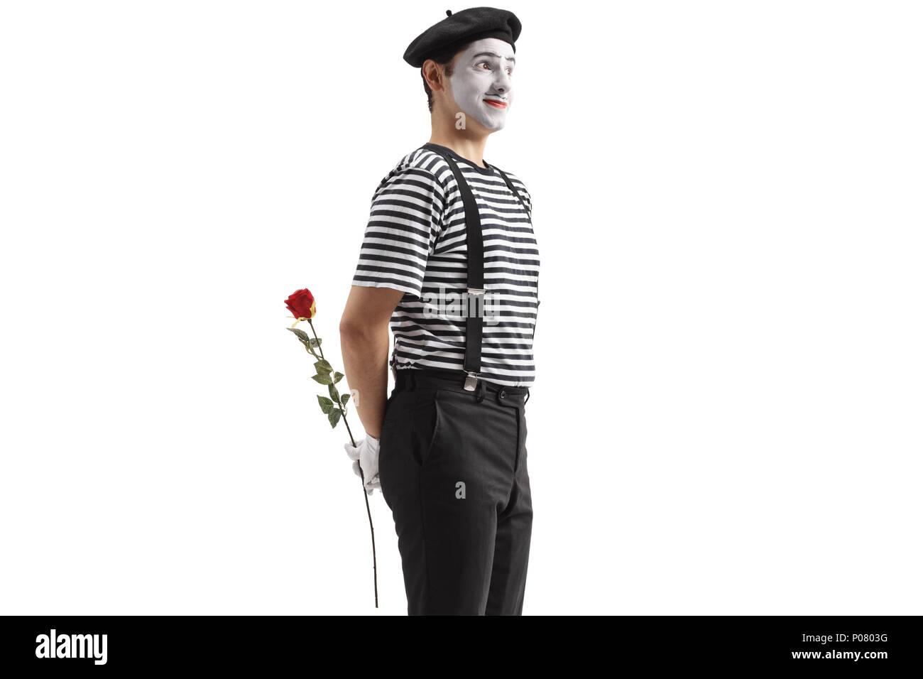 Mime holding a rose flower behind his back isolated on white background ...