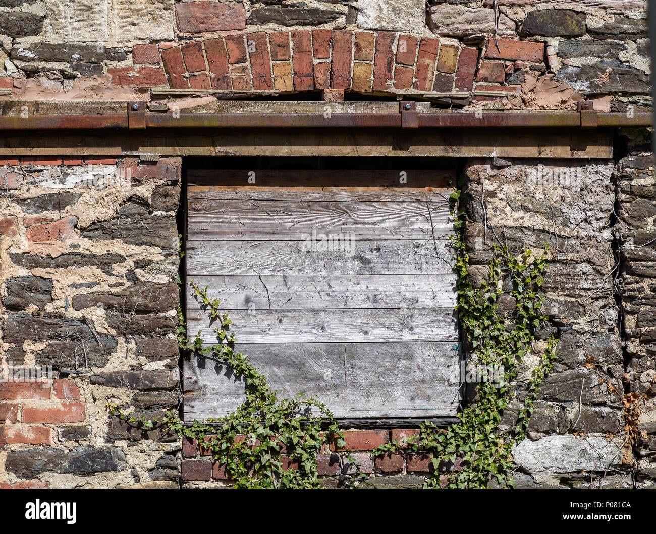 An old stone barn window boarded up with wood Stock Photo - Alamy