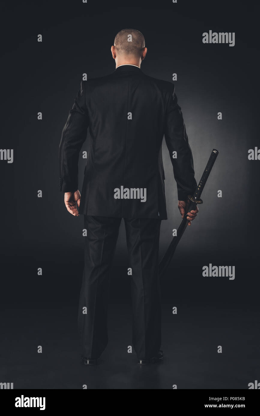 rear view of man in suit with katana sword on black Stock Photo - Alamy