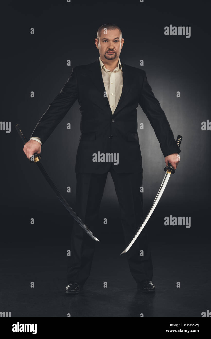 man in costume with dual katana swords on black Stock Photo - Alamy