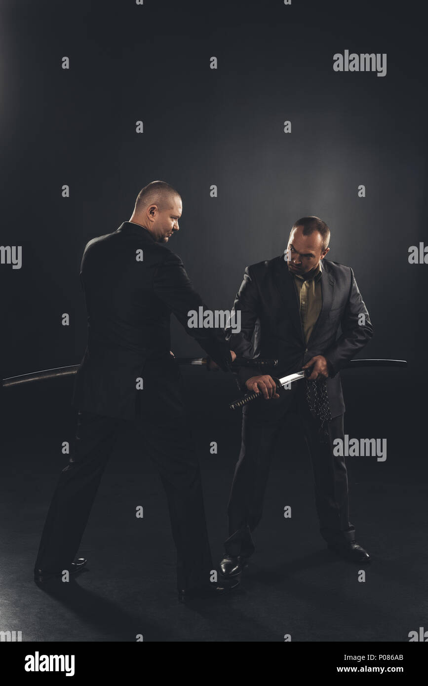 businessmen taking out katana swords for fight isolated on black Stock ...