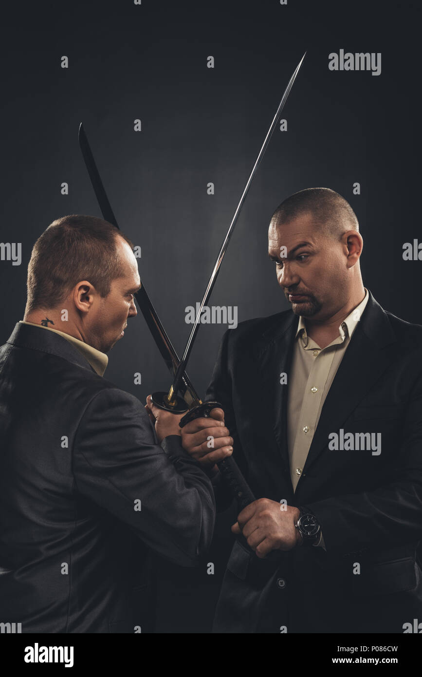 businessmen fighting with katana swords isolated on black Stock Photo ...