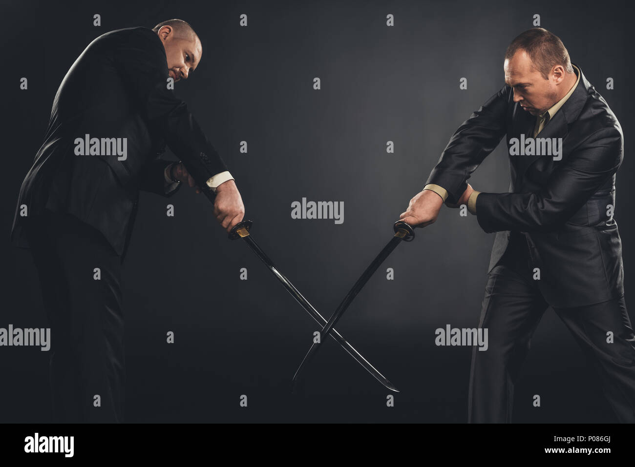 businessmen fighting with katana swords isolated on black Stock Photo ...