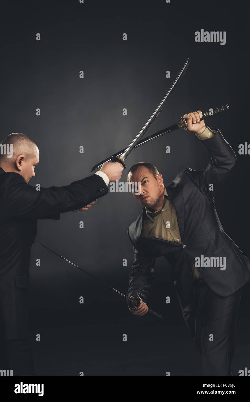 modern samurai in suits fighting with swords on black Stock Photo - Alamy