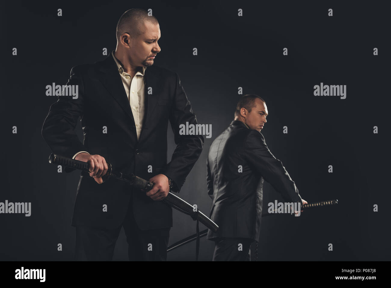 two handsome modern samurai with katanas isolated on black Stock Photo ...