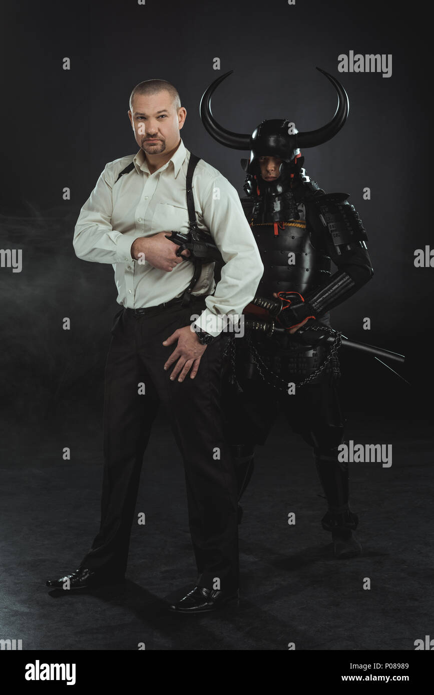 man with gun and samurai behind him on black Stock Photo - Alamy