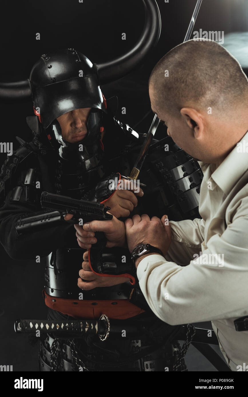 close-up shot of armored samurai fighting with man who holding gun ...