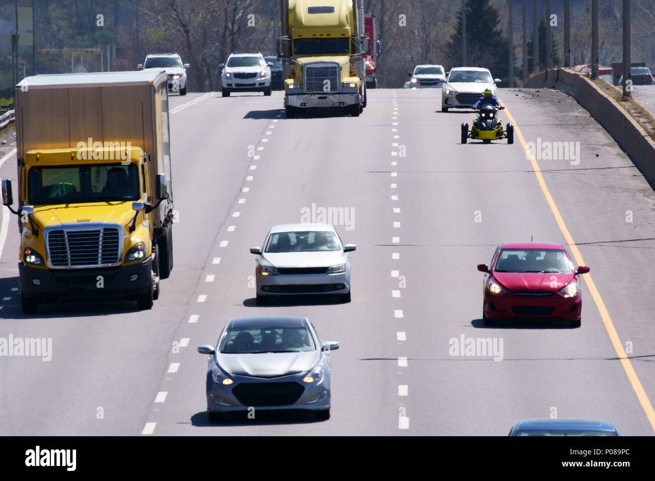 Cars on an expressway or highway, front or towards us, day, sunny. We ...