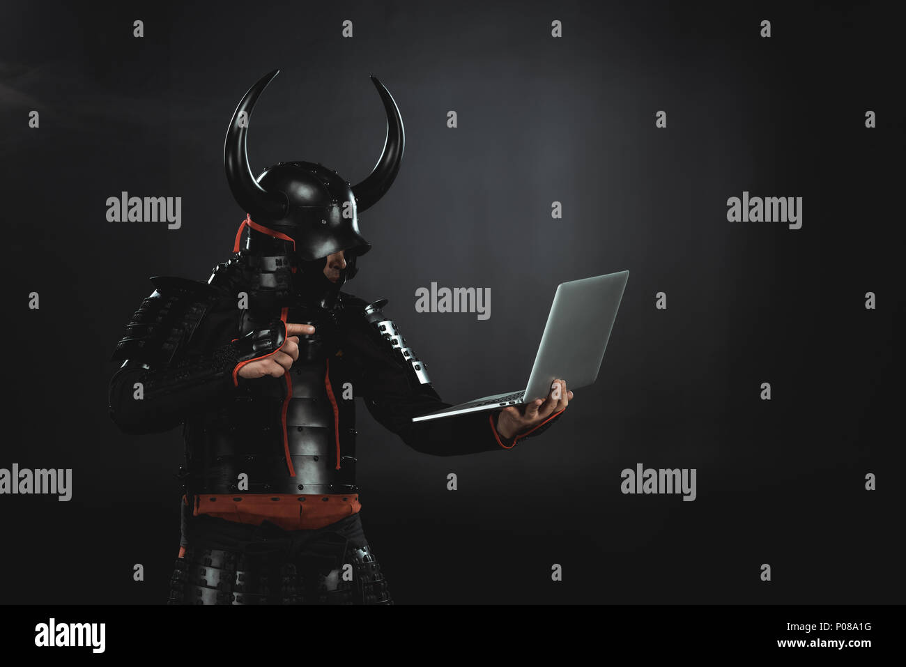 side view of armored samurai using laptop on black Stock Photo - Alamy