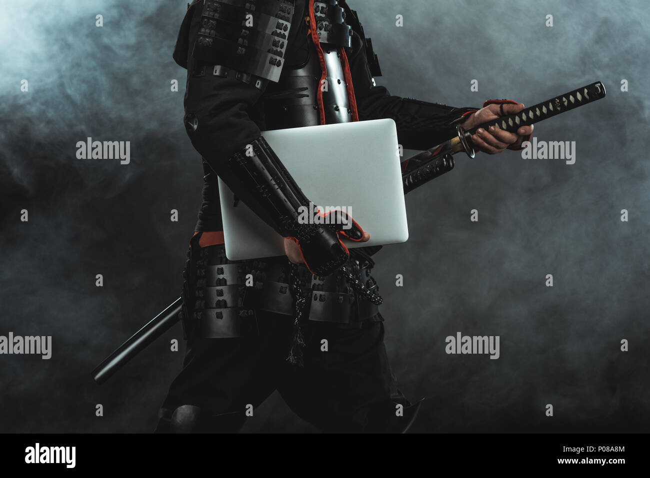 cropped shot of samurai in traditional armor with laptop taking out ...