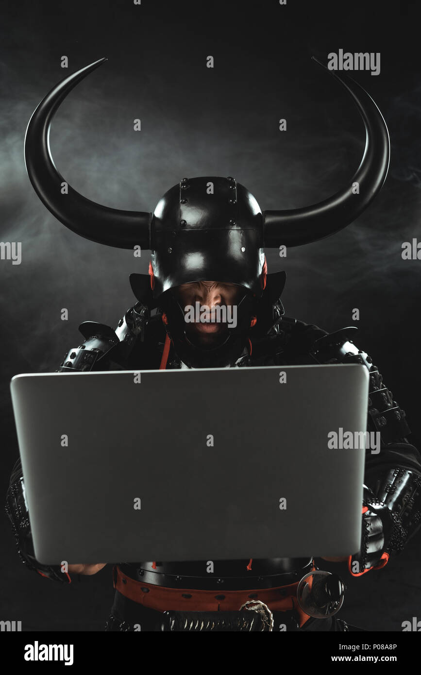 angry samurai in armor using laptop on dark background with smoke Stock ...