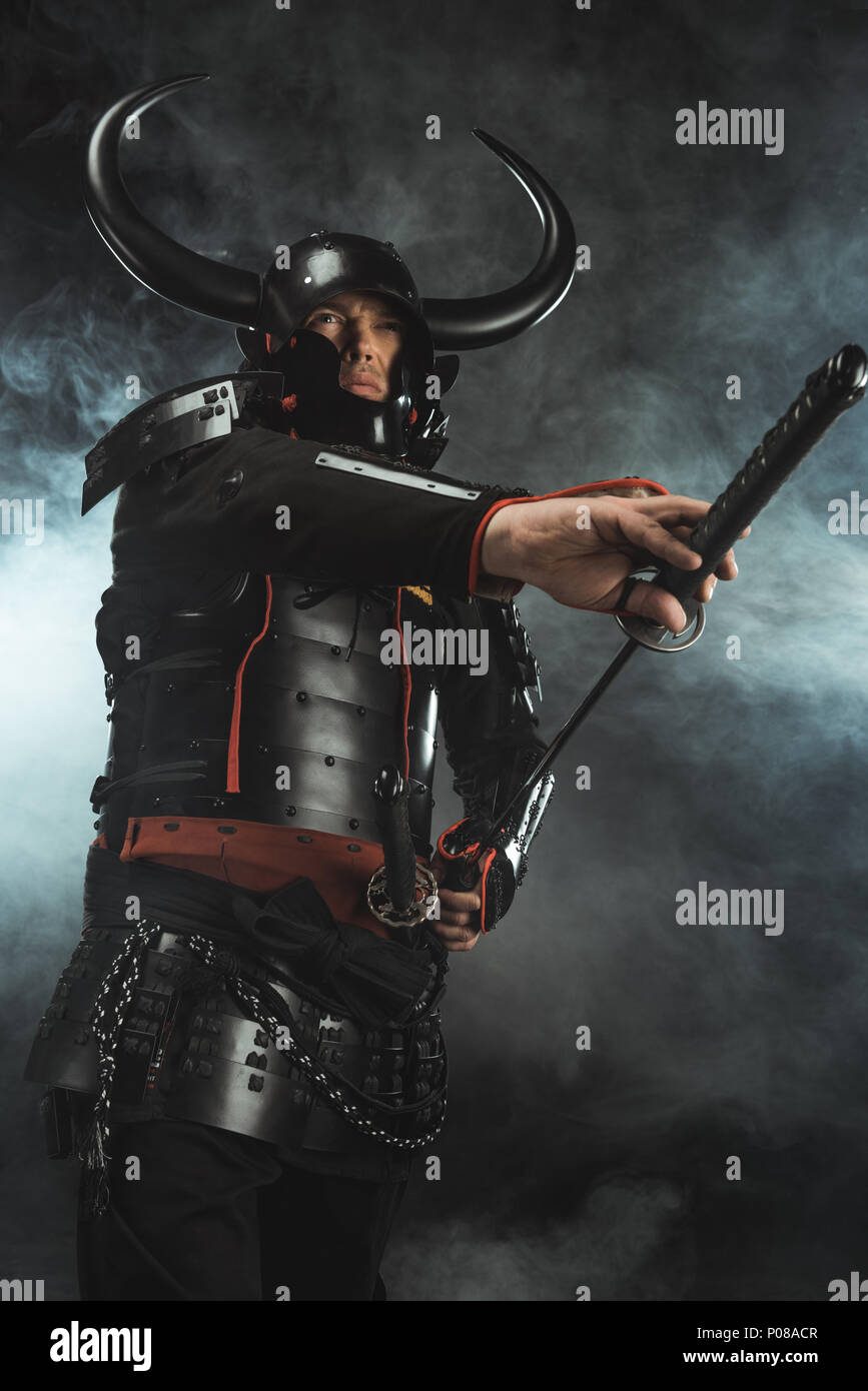 bottom view of samurai taking out his katana on dark background with ...