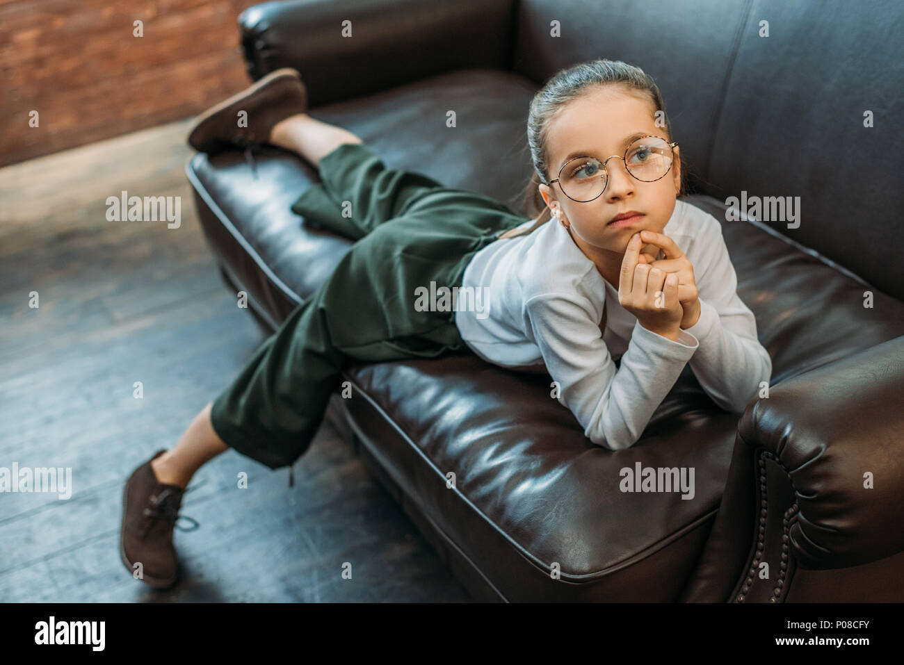 thoughtful little child relaxing on couch at home Stock Photo - Alamy