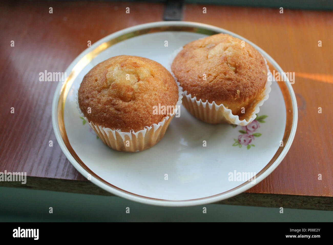 two vegetarian fresh muffin with cream inside lay on plate for dessert ...