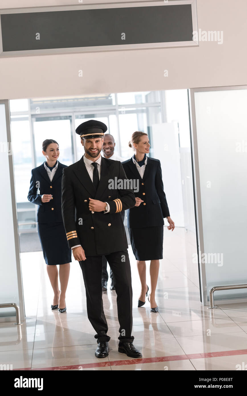 handsome young pilot walking by airport with his team Stock Photo - Alamy