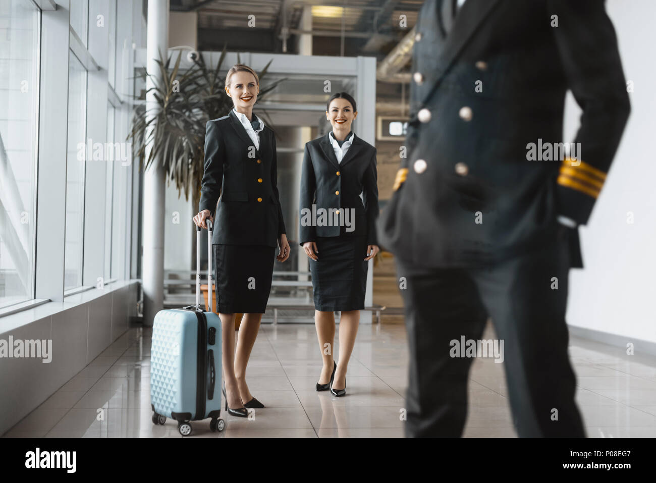 stewardesses looking at pilot at airport lobby before flight Stock ...