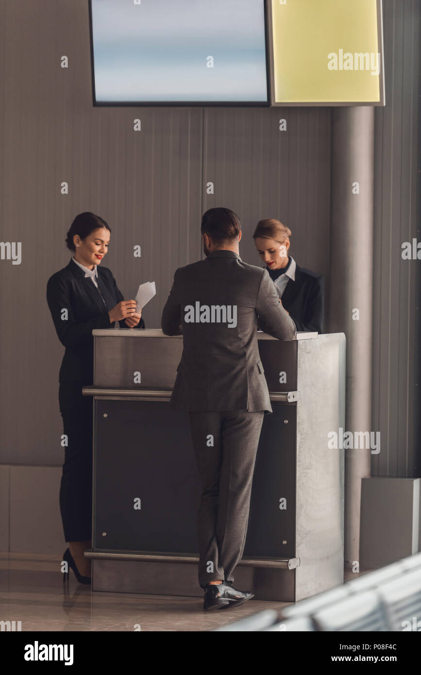 rear view of businessman standing at airport check in counter Stock ...
