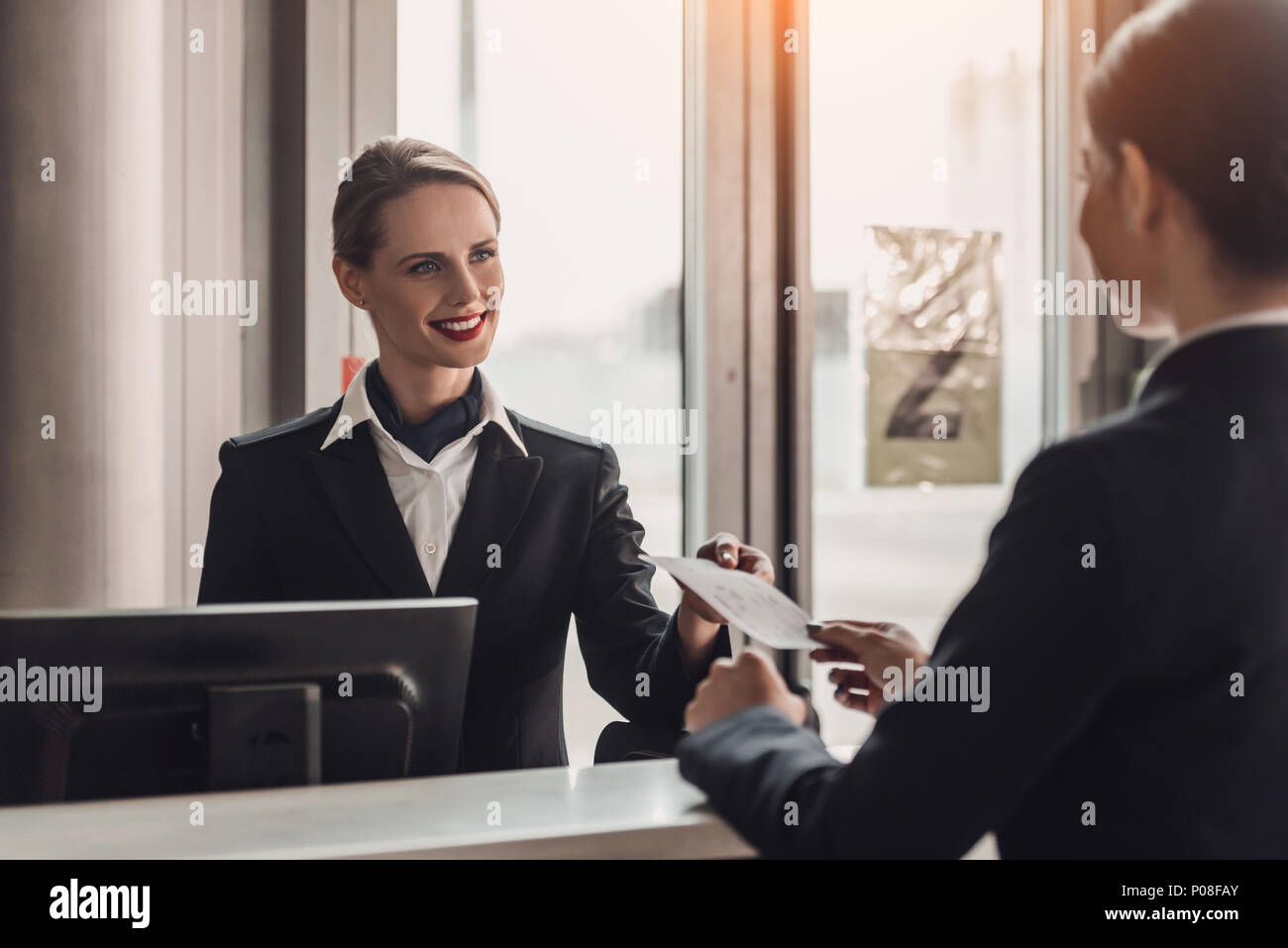 young businesswoman giving ticket to staff at airport check in counter ...