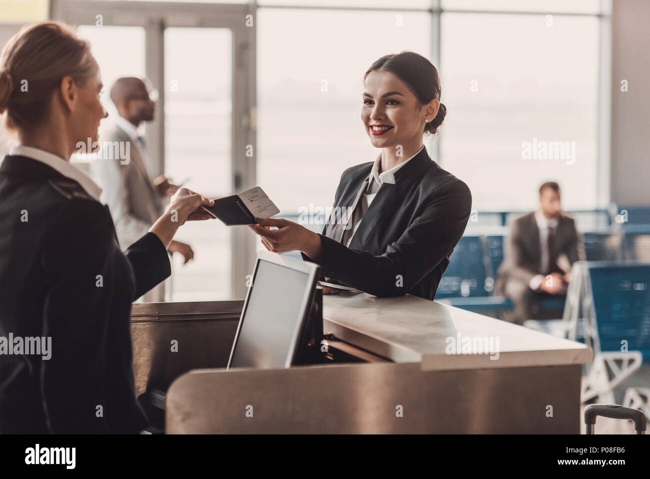 happy businesswoman giving passport and ticket to staff at airport ...