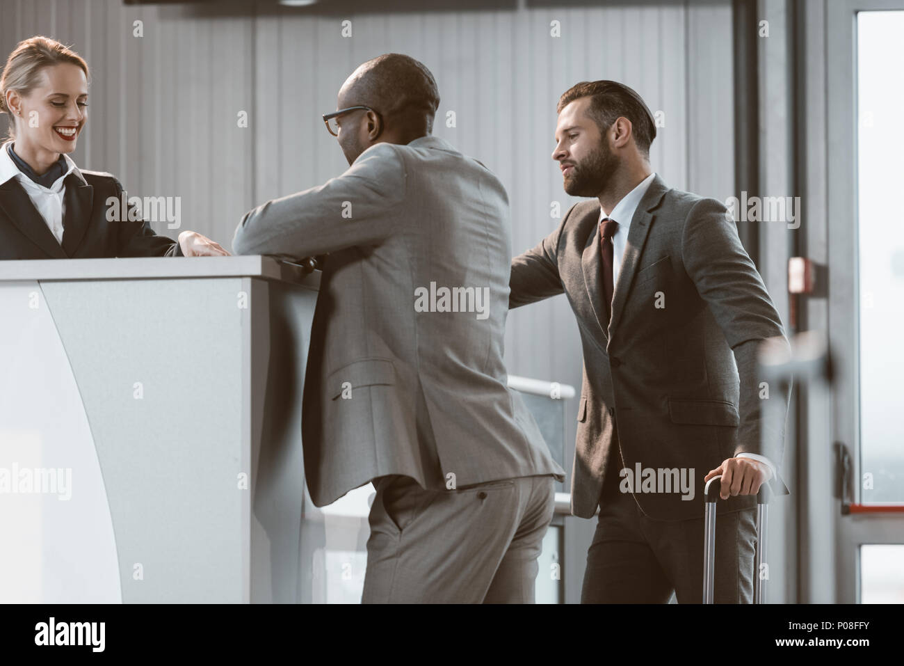 businessmen standing at airport reception to buy tickets Stock Photo ...