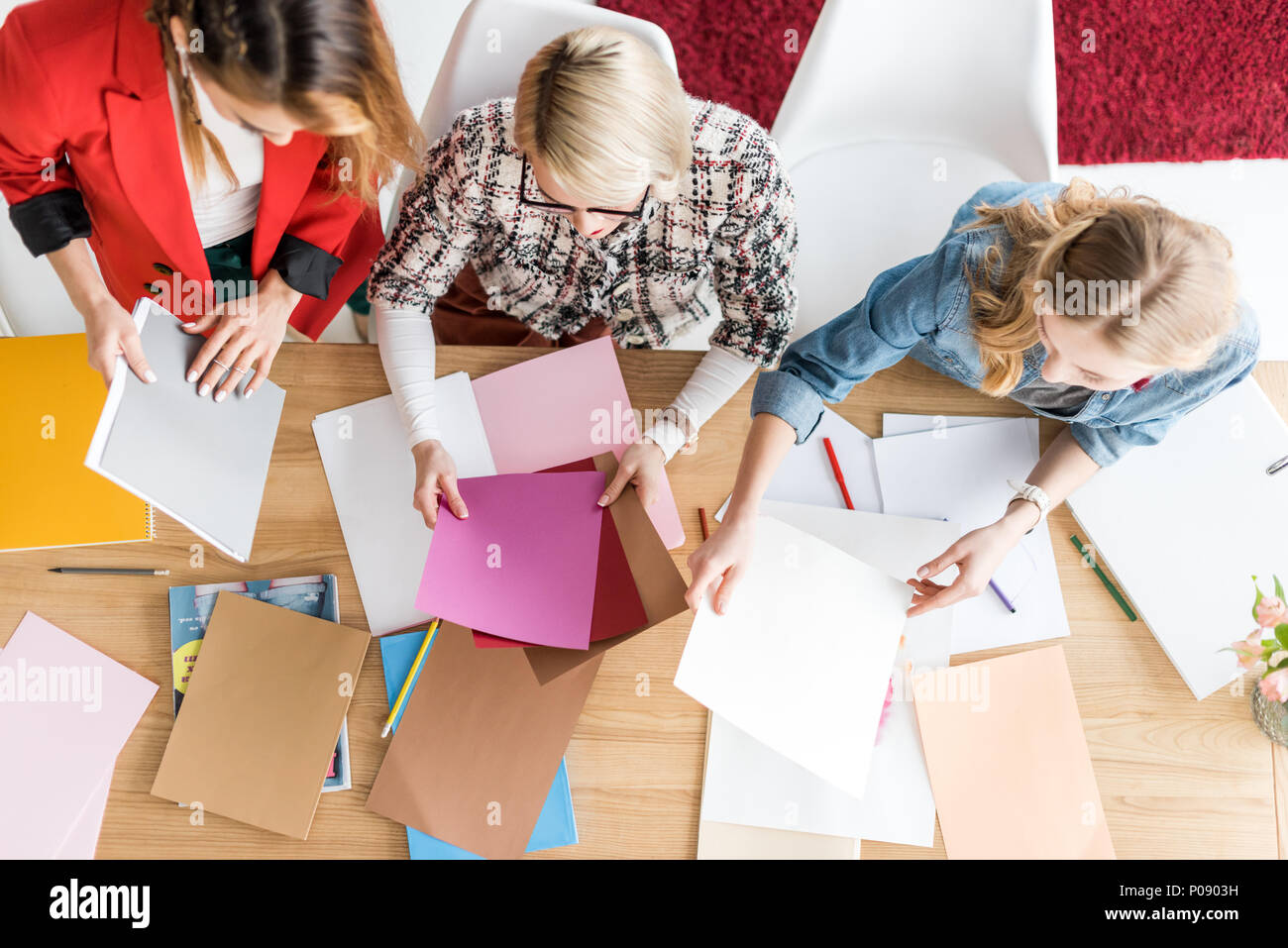 overhead view of fashionable magazine editors working with color ...