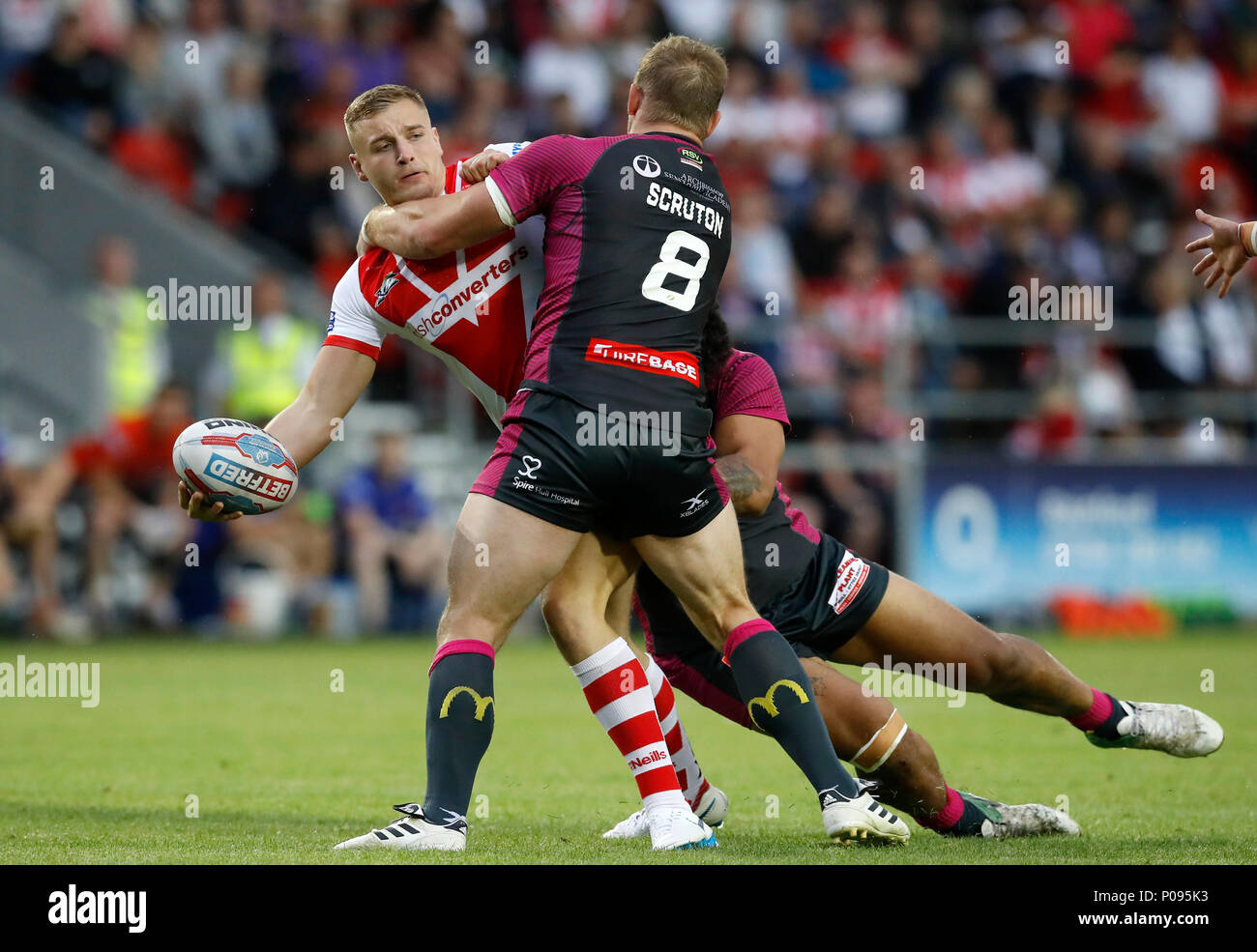 St Helens' Matthew Lees (left) is tackled by Hull KR's Mose Masoe (back ...