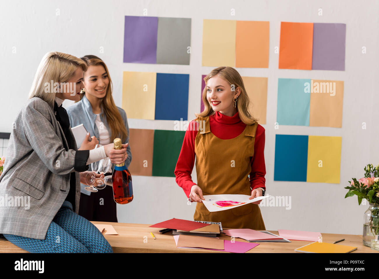 successful magazine editors celebrating with champagne in modern office ...