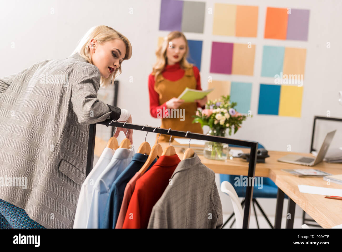 fashionable magazine editors working with clothes in modern office ...
