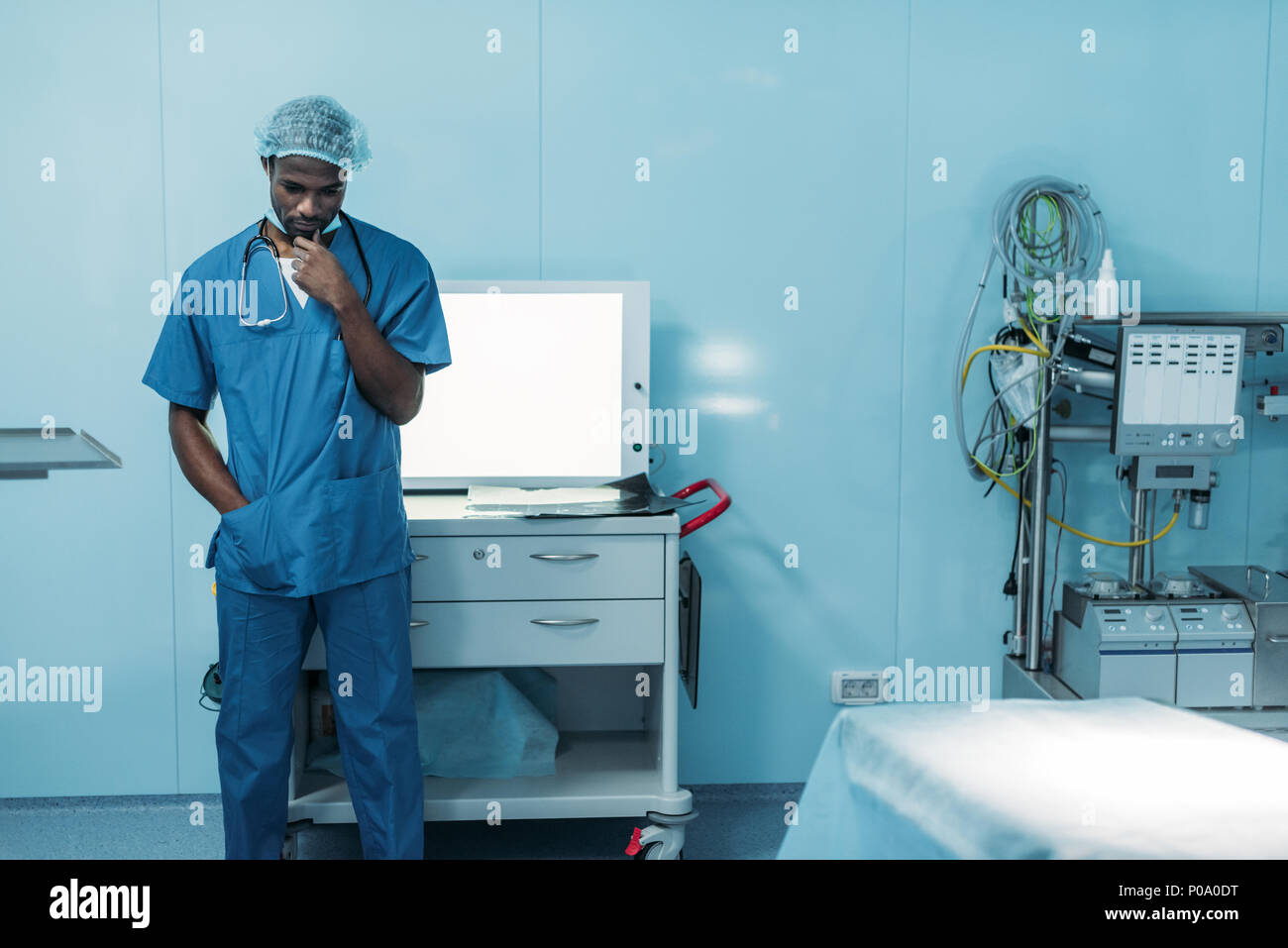 sad african american doctor standing in operating room Stock Photo - Alamy