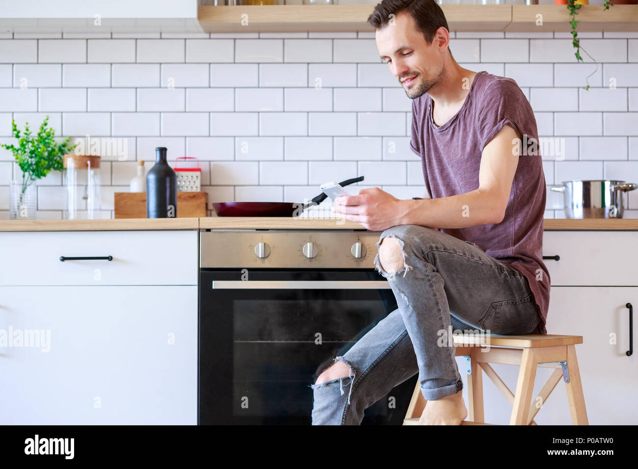 Image of man with frying pan and phone in hands in kitchen Stock Photo ...