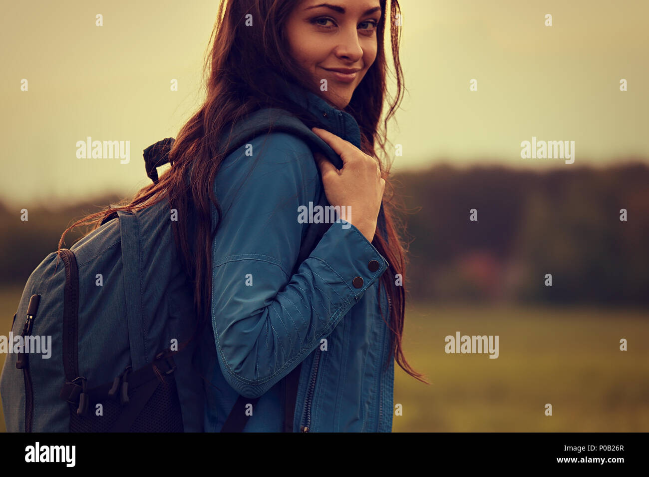 Happy backpacking adventurous woman have a camping trip with blue huge ...