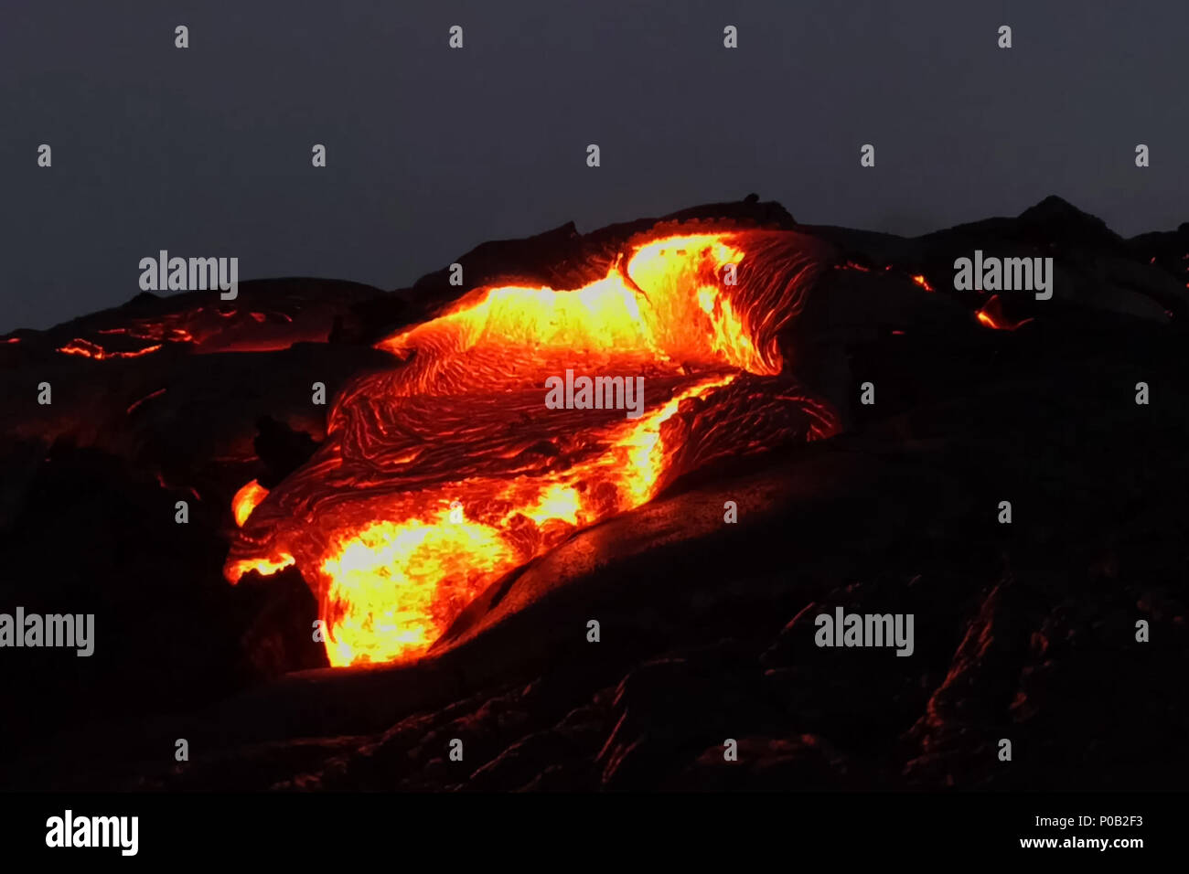 Pouring lava on the slope of the volcano. Volcanic eruption and magma ...