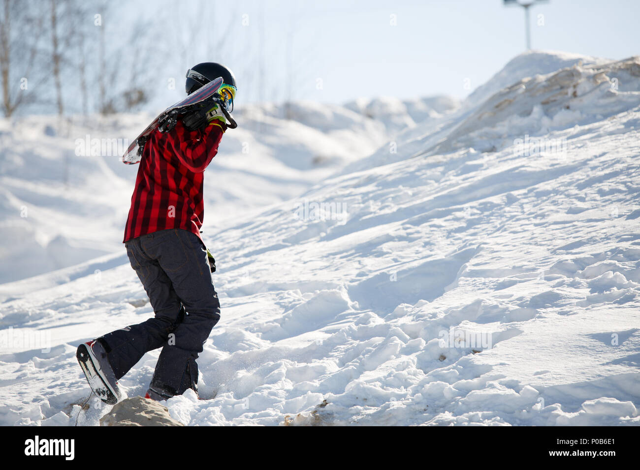 Image of man with snowboard walking on snowy mountain slope Stock Photo ...