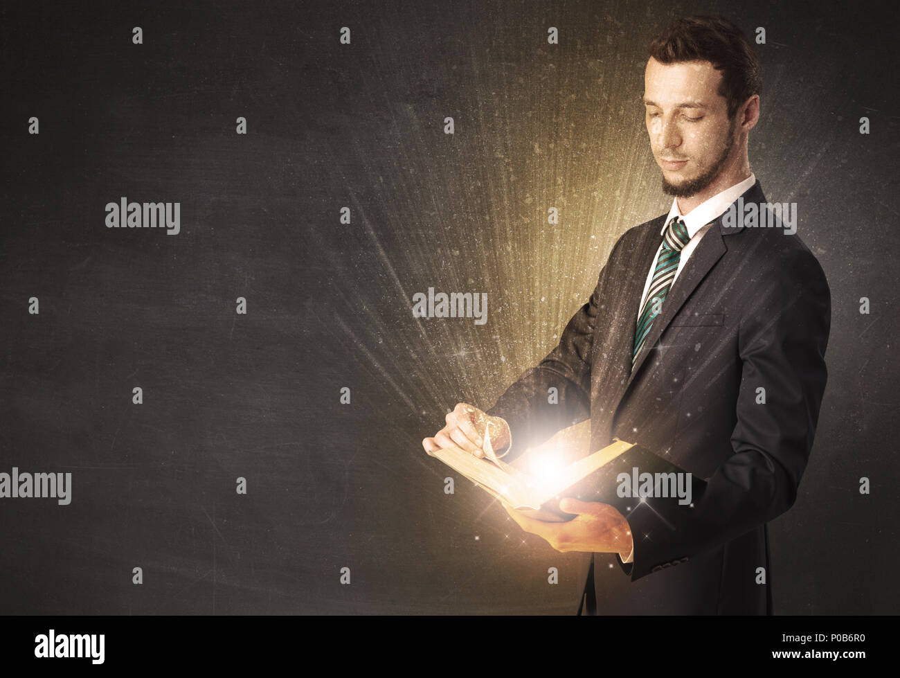 Man holding and reading a shiny book Stock Photo - Alamy