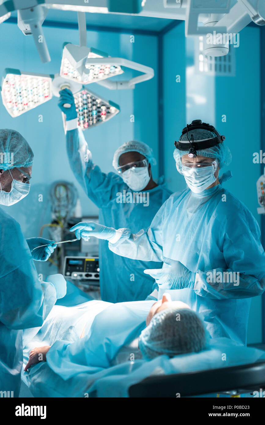 multiethnic surgeons operating female patient Stock Photo - Alamy